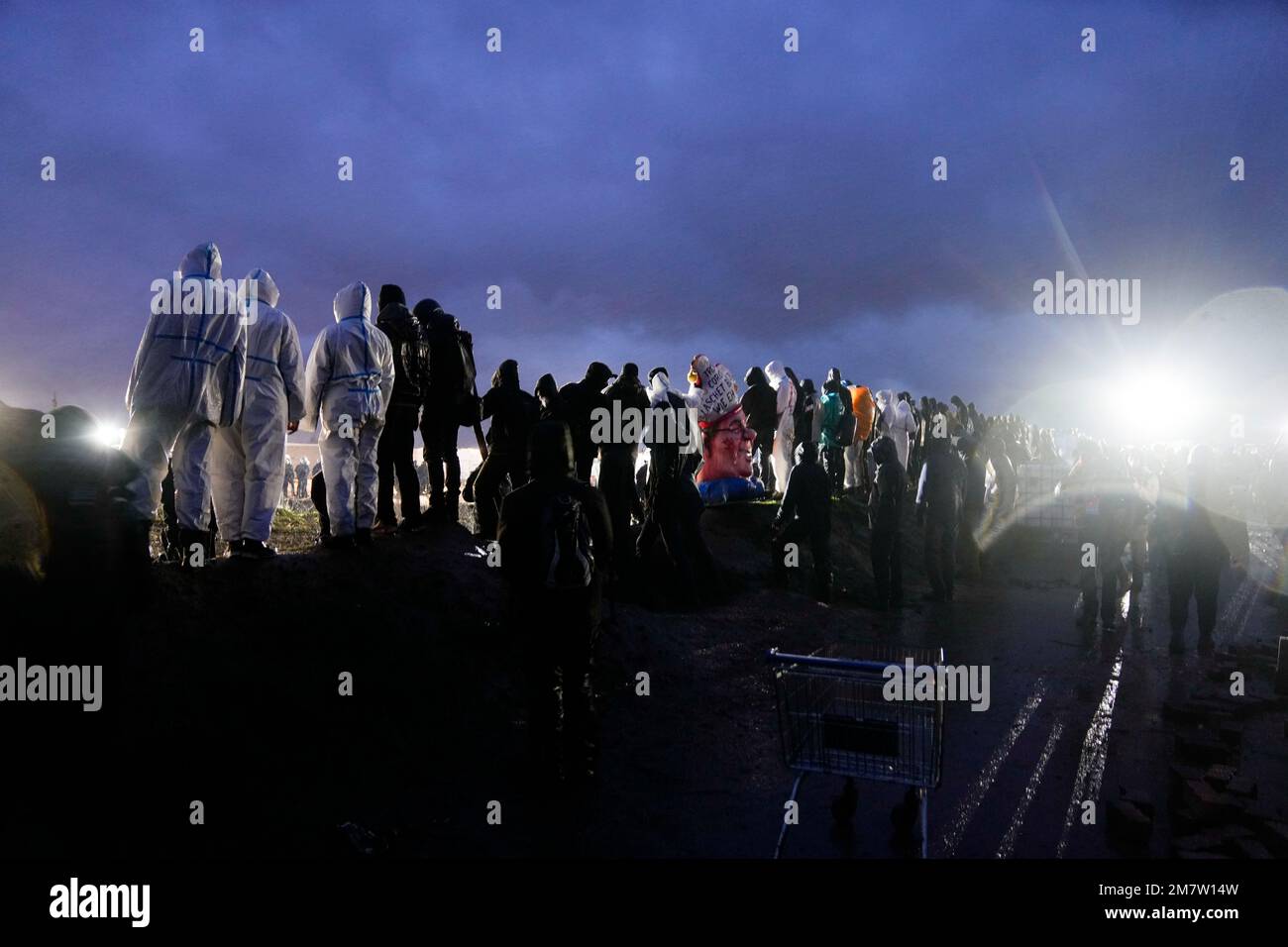 Climate activist stand in front of police officers in riot gear at the ...
