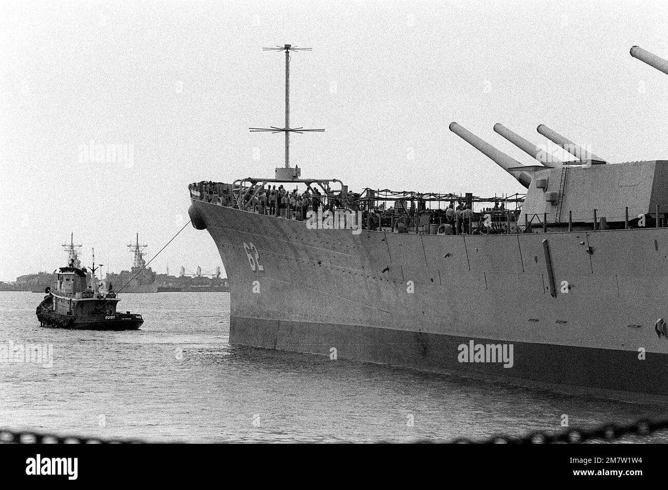 Tugs pull the battleship NEW JERSEY (BB-62) out of drydock. After 12 ...