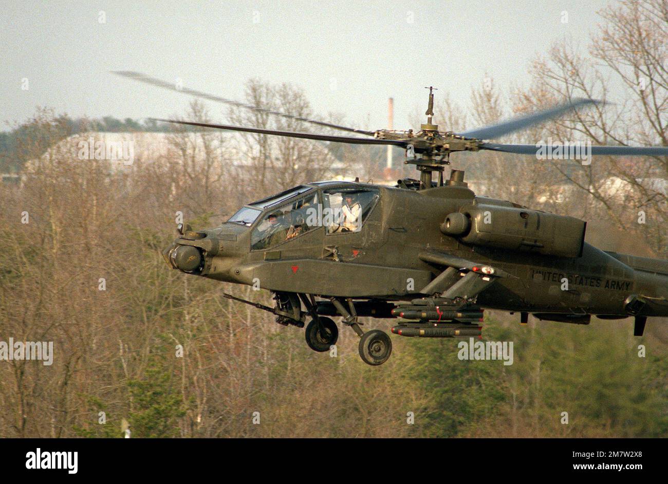 A left side view of a YAH-64 Apache helicopter prototype during a demonstration flight. It is ...
