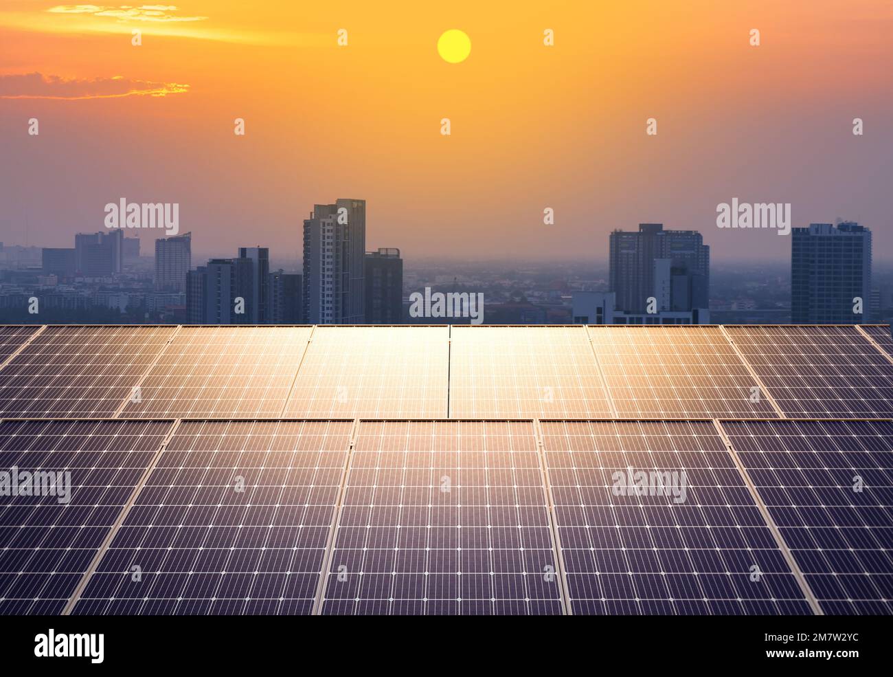 Solar panels on the rooftops of tall buildings reflect the sunset in ...