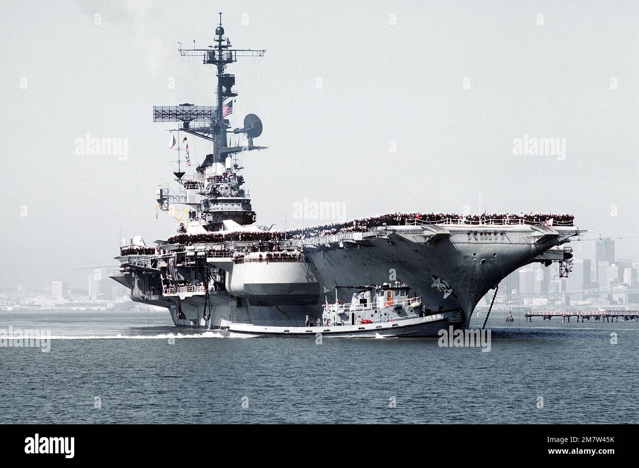 The large harbor tug USS ACCONAC (YTB-812) nudges the starboard bow of ...