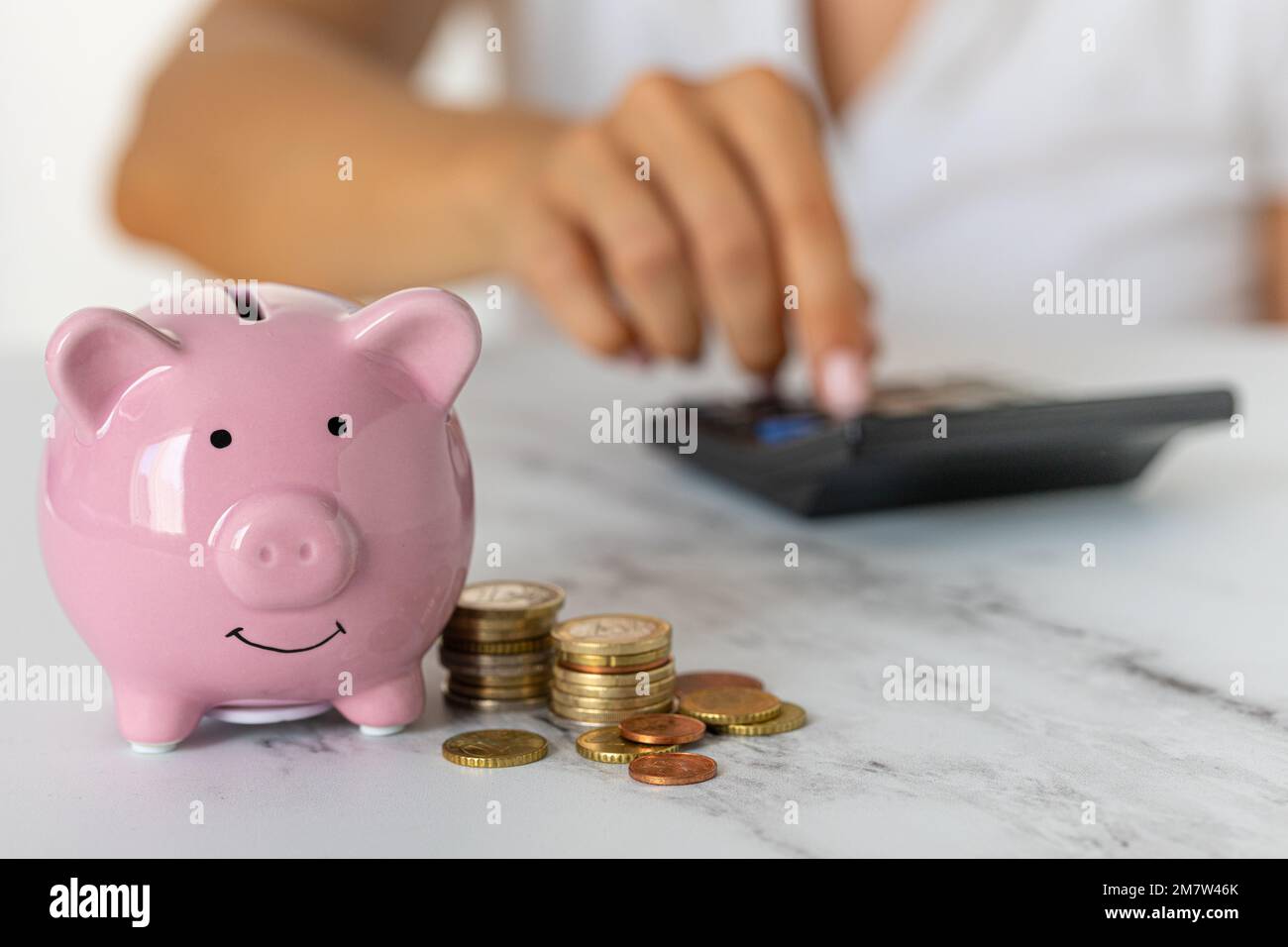 Close-up of a woman's hands counting expenses on a calculator with a ...