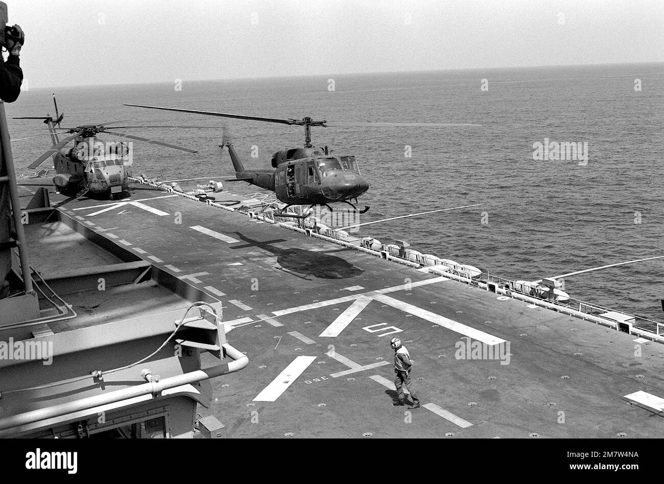 A UH-1E Iroquois helicopter takes off from the deck of the amphibious ...