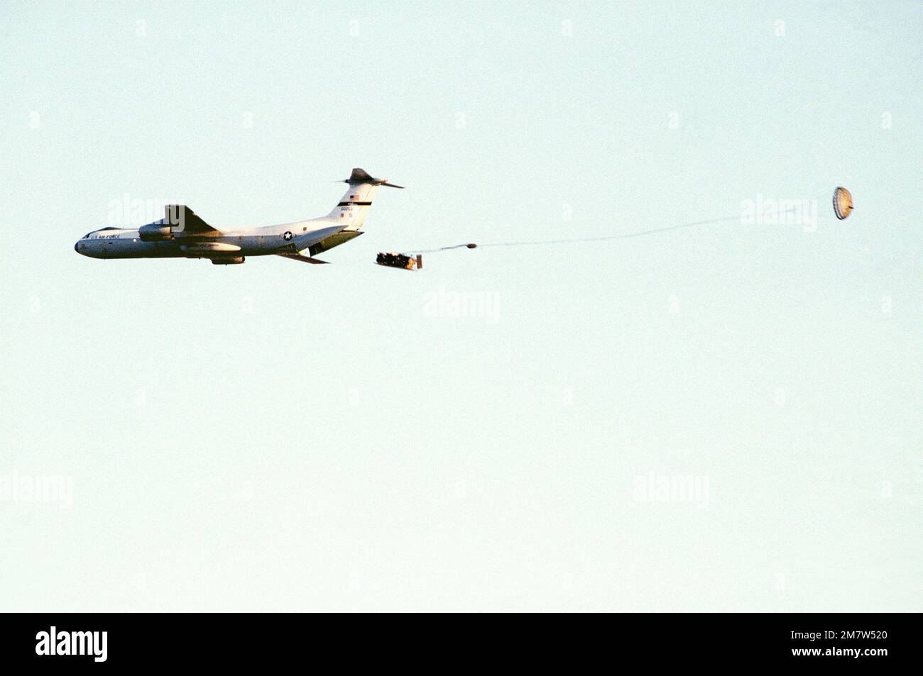 Cargo is dropped by parachute from a C-141 Starlifter aircraft into ...