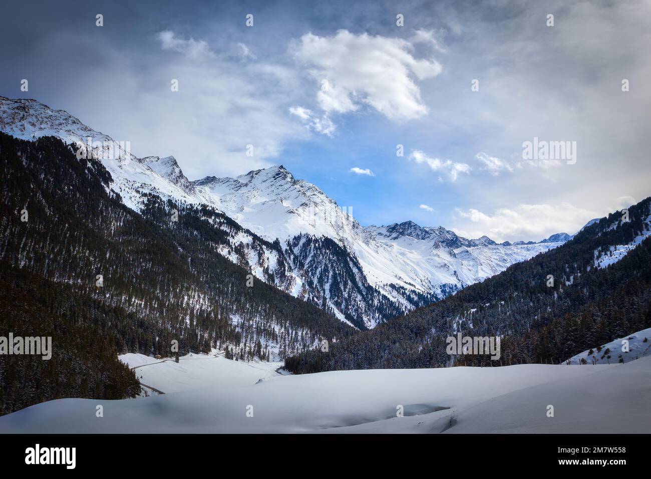 An aerial view of snow covered mountain landscape with dense trees ...