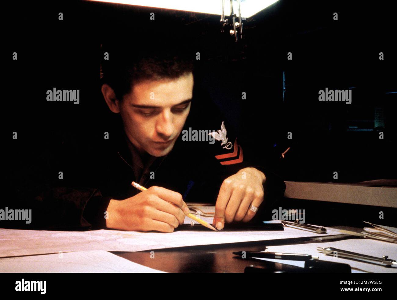 A petty officer second class operations specialist (OS2) plots a course ...