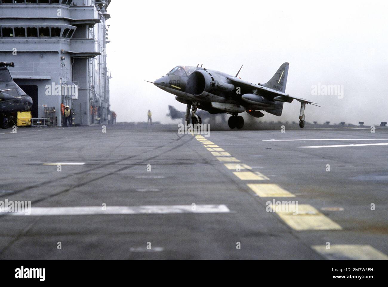 A left side view of an AV-8 Harrier aircraft beginning its takeoff from the deck of the ...
