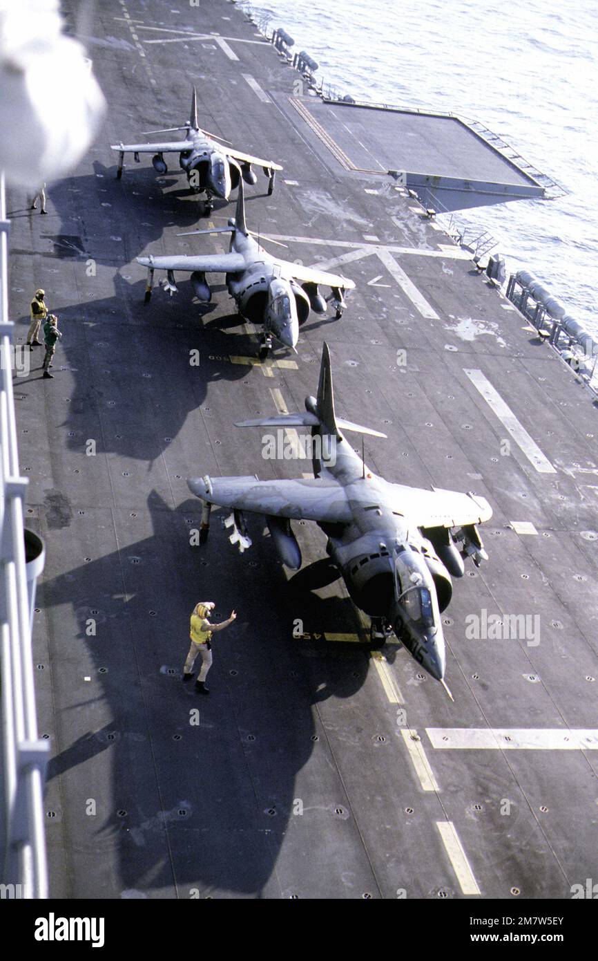 Three AV-8A Harrier aircraft are lined up on the flight deck of the ...