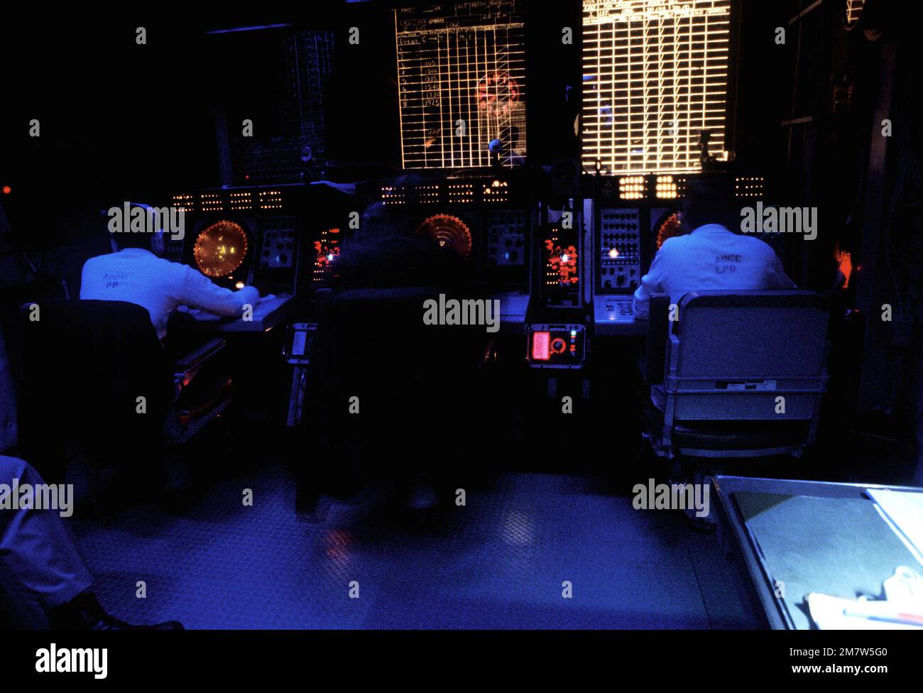 Crewmen monitor radar scopes in the combat information center aboard ...