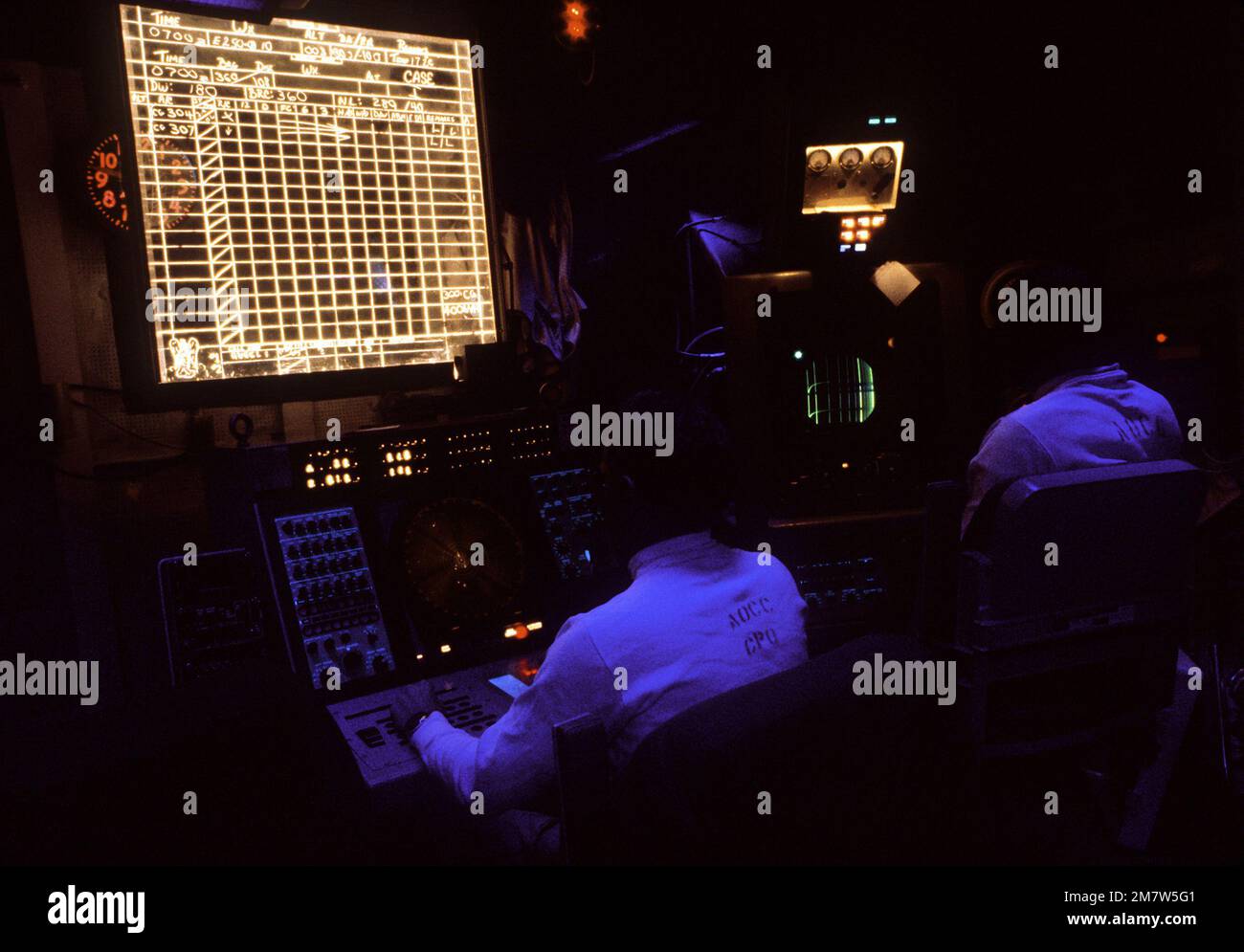 Crewmen monitor radar scopes in the combat information center aboard ...