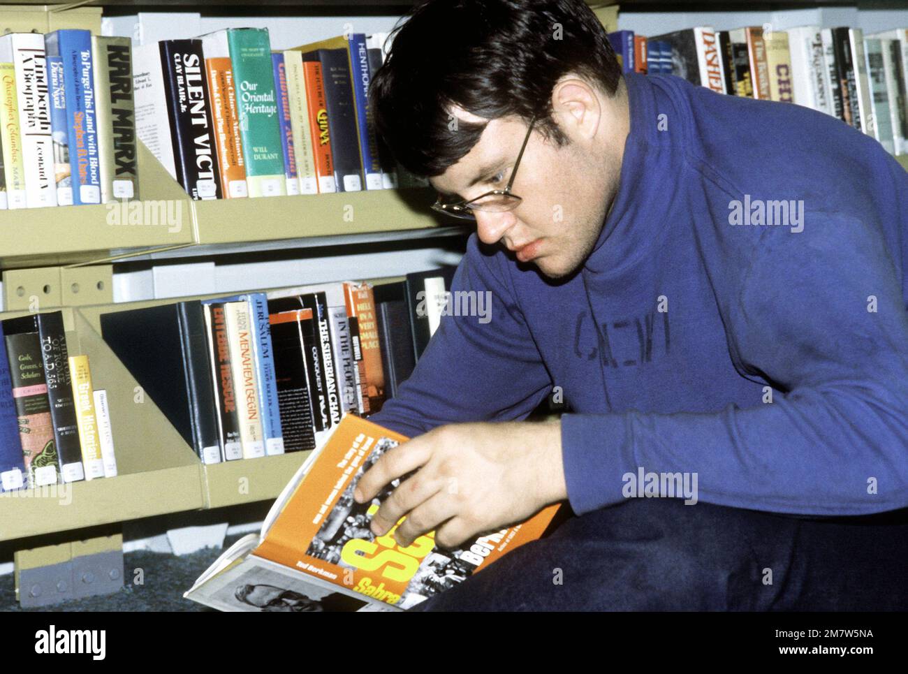 A crewman uses the library aboard the amphibious assault ship USS ...