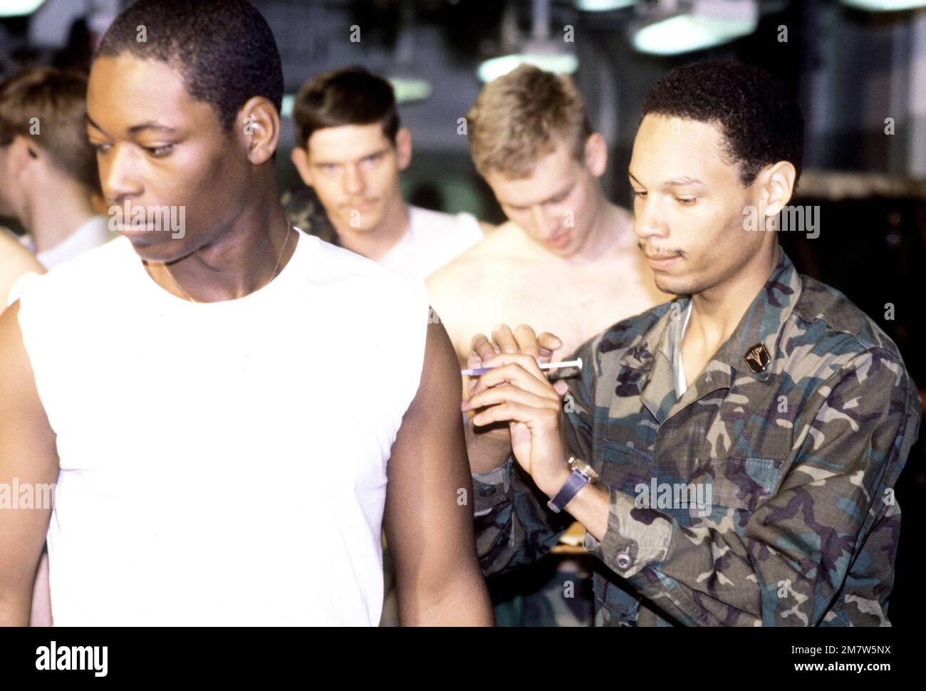 Marines receive inoculations from a corpsman aboard the amphibious ...