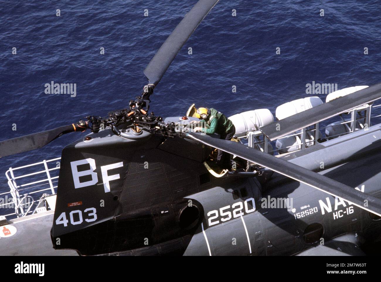 A flight deck crewmen checks the rotor of a Helicopter Combat Support ...