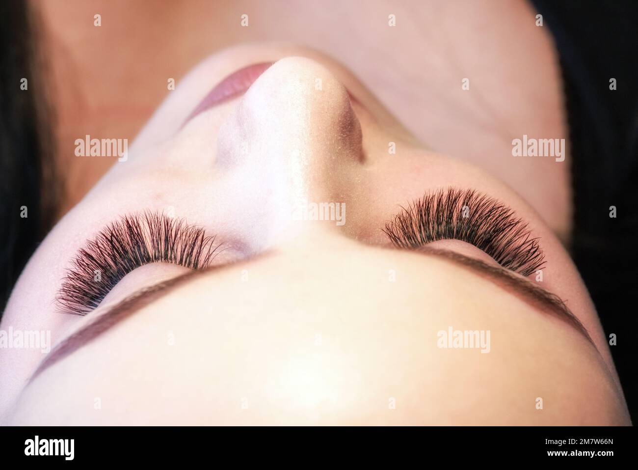 Eyelash extension procedure. Beautiful Woman with long lashes and ...