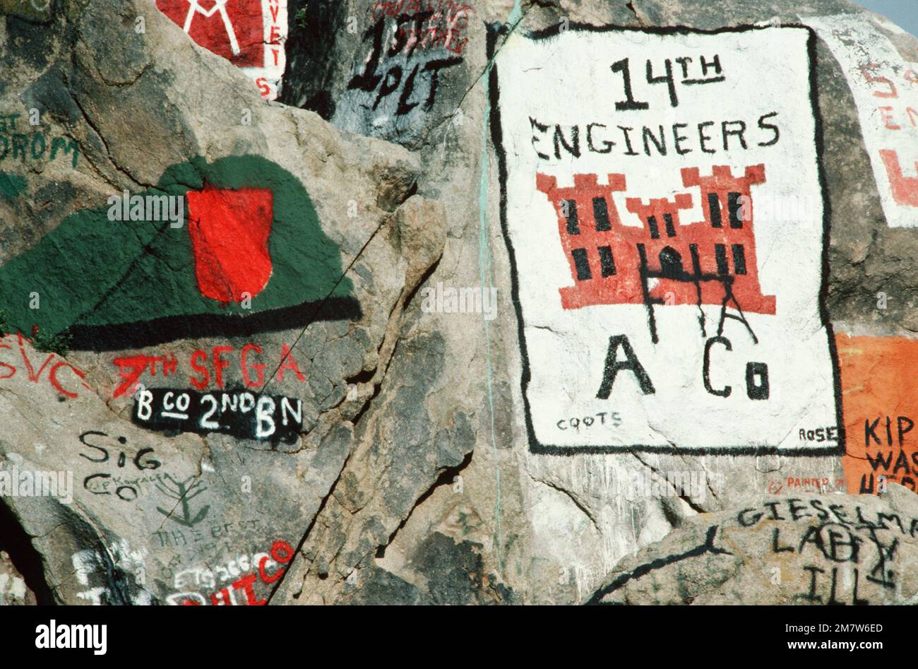 Organizational emblems and symbols appear on a rock formation outside ...