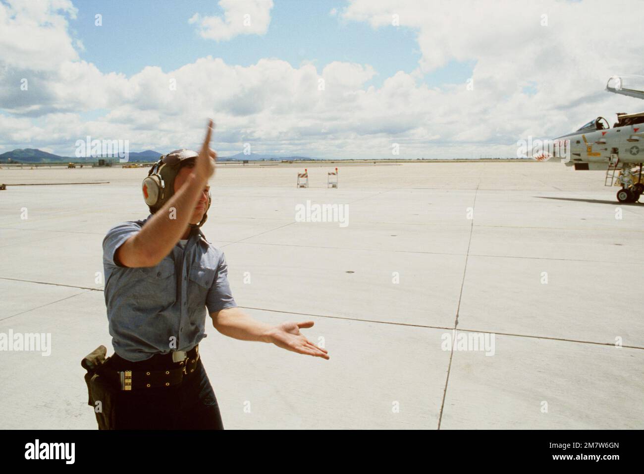A ground crewman signals an F-14 Tomcat aircraft pilot as he conducts a ...