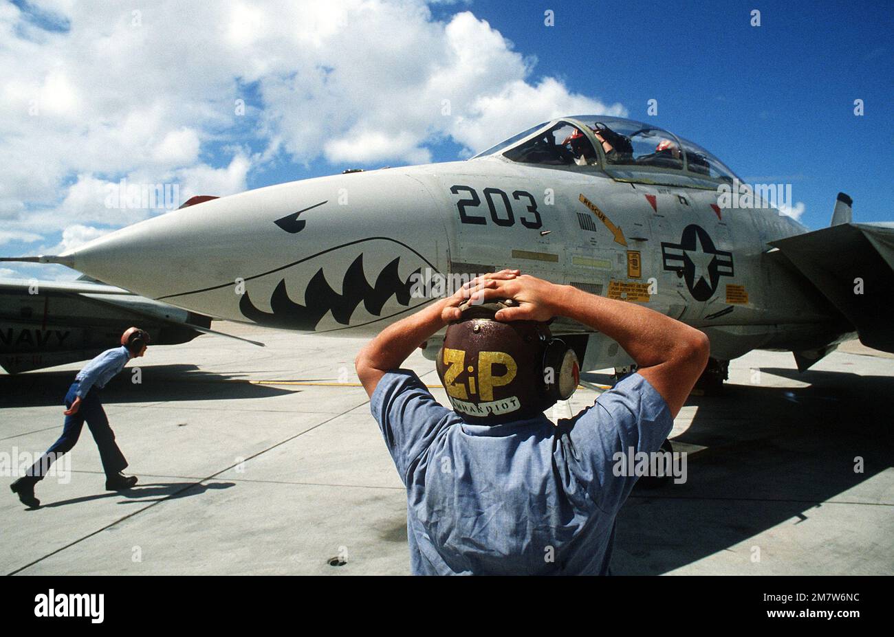 A ground crewman signals an F-14 Tomcat aircraft pilot as he conducts a ...