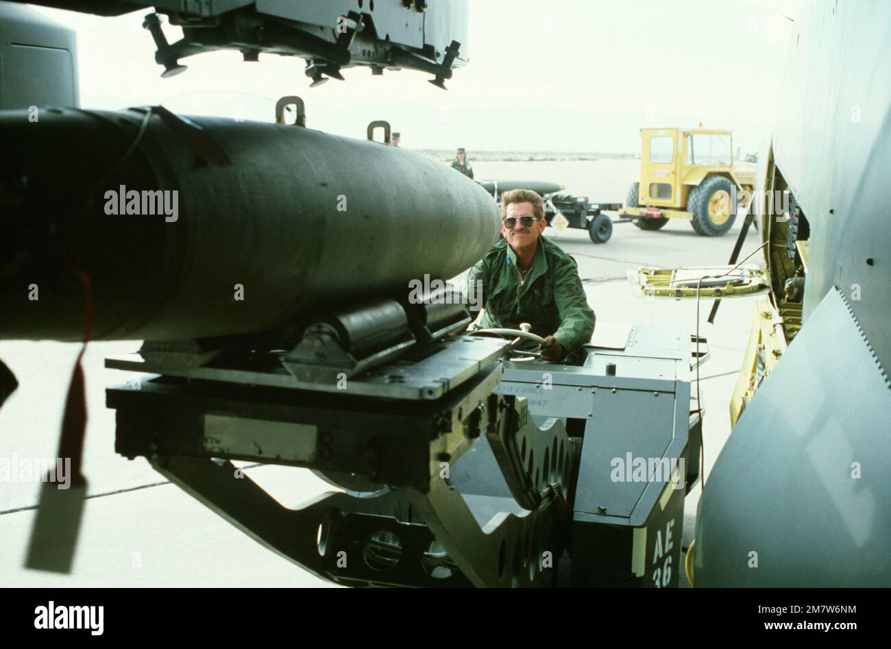 A weapons technician operates a bomb loader to upload a bomb onto the ...