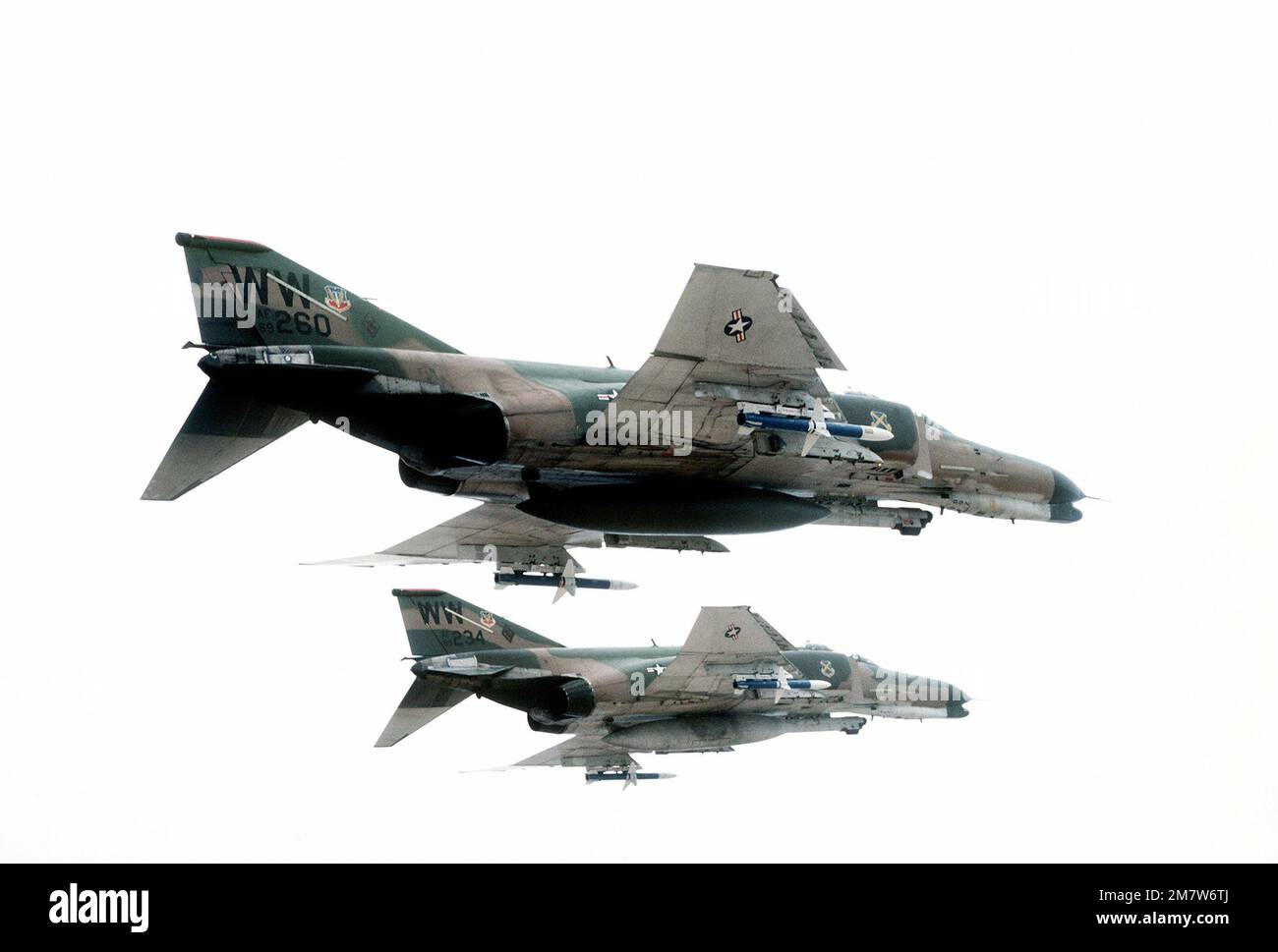 An air-to-air right underside view of two F-4 Phantom II aircraft ...