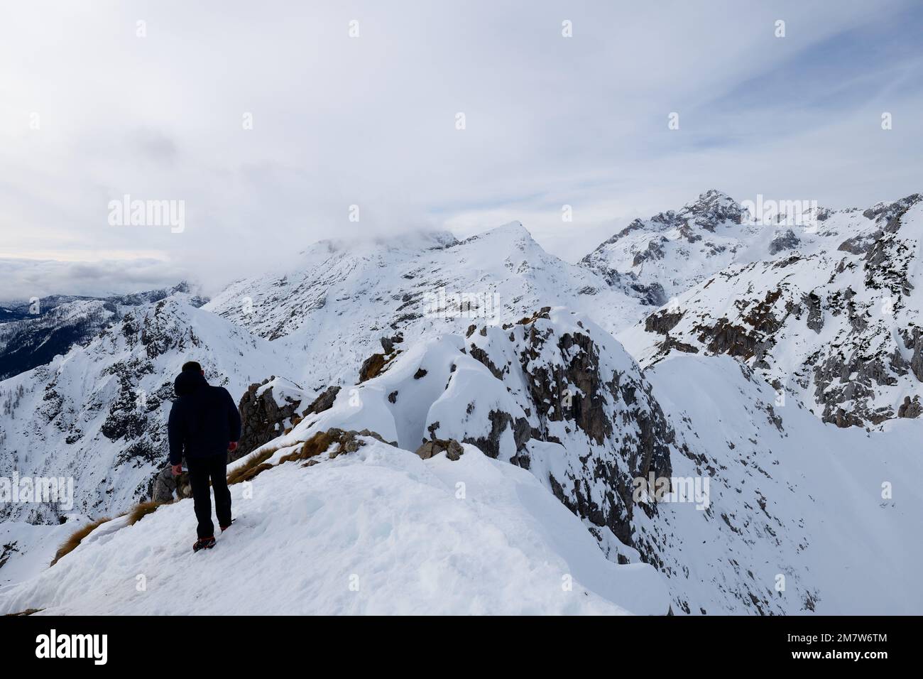 A person admiring the vast winter mountain landscape with Mount Triglav ...