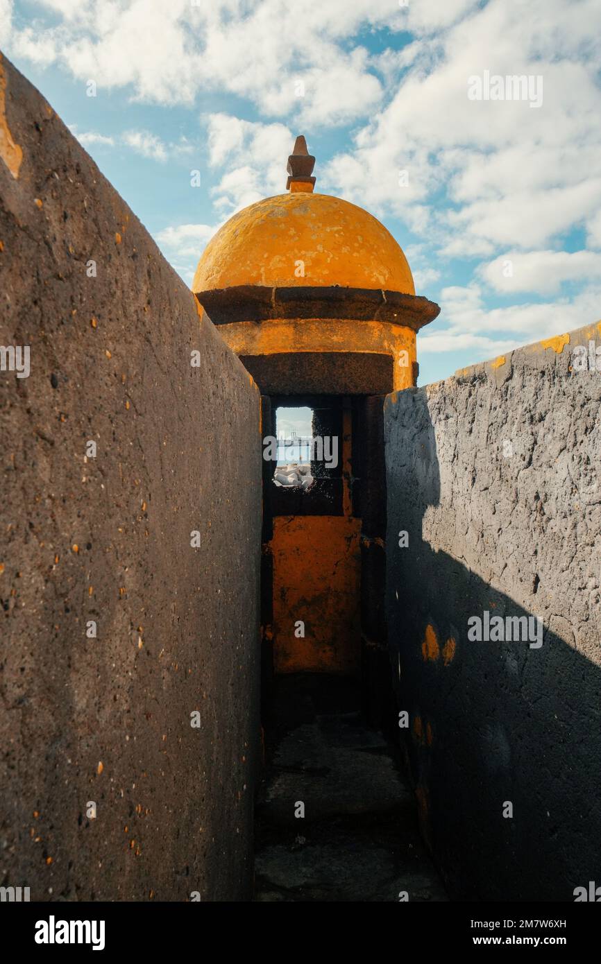 A vertical shot of a walkway to the tower with a yellow dome, Medeira ...