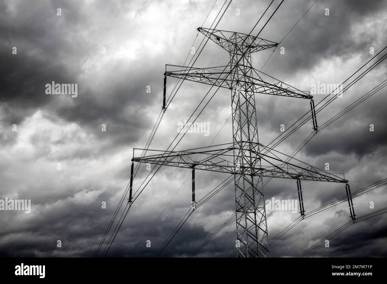 Electricity transmission power lines and dark clouds on sky Stock Photo ...