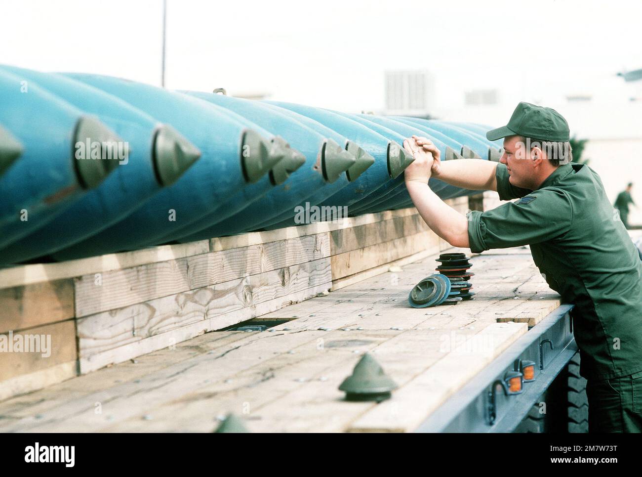 A member of the 5th Munitions Maintenance Squadron tightens the nose ...
