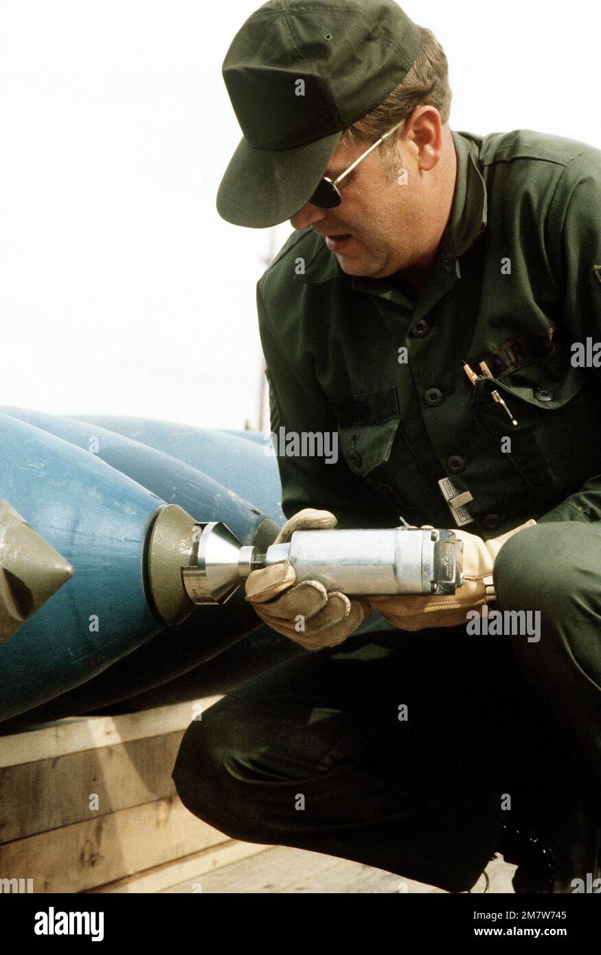 A member of the 5th Munitions Maintenance Squadron tightens the nose ...