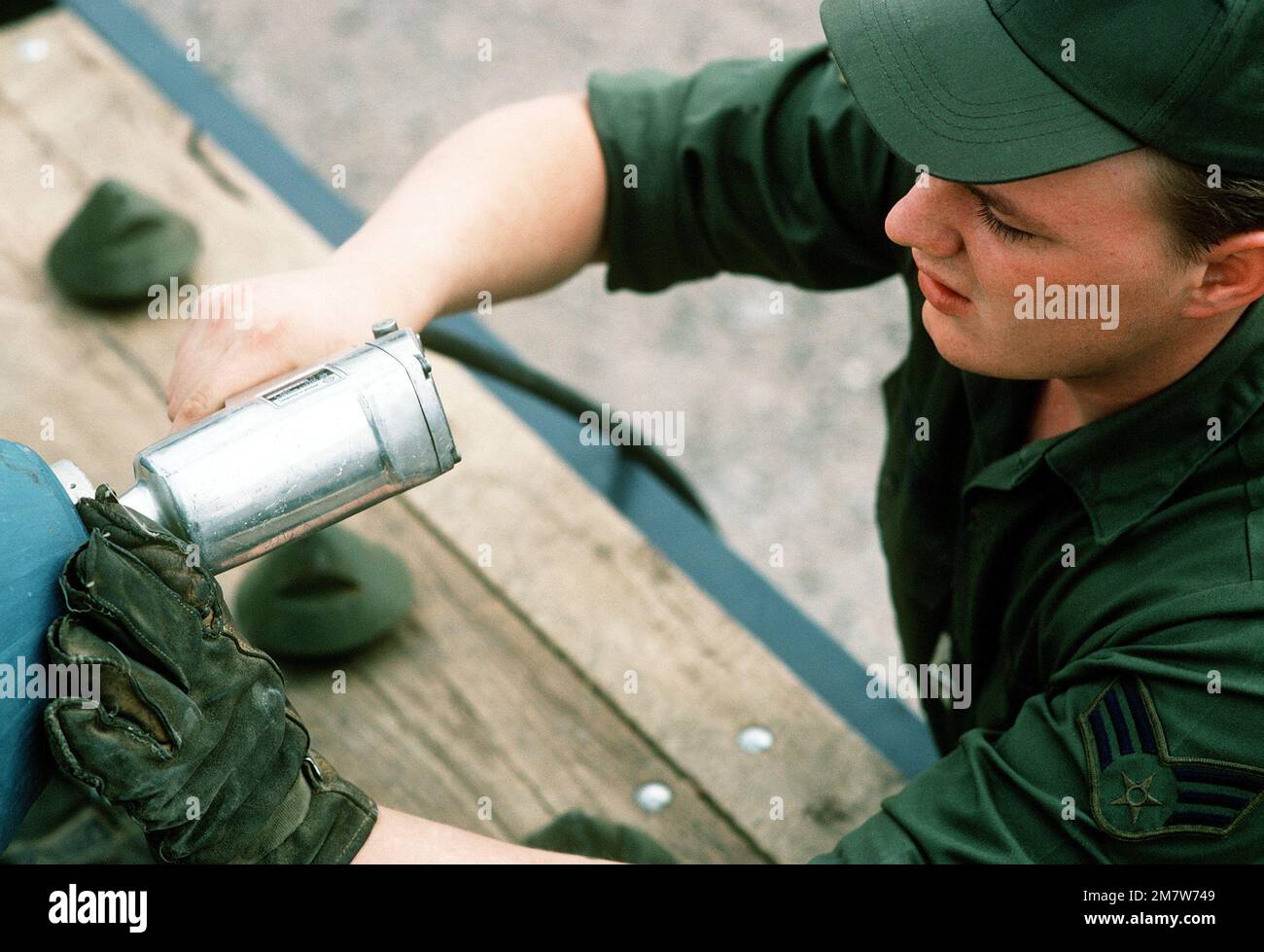 A member of the 5th Munitions Maintenance Squadron tightens the nose ...