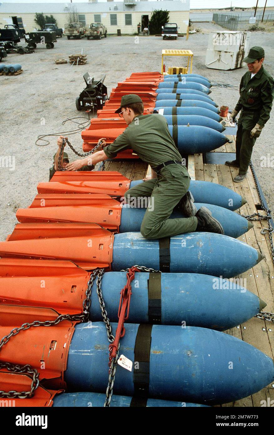 Personnel from the 5th Munitions Maintenance Squadron secure 750-pound ...