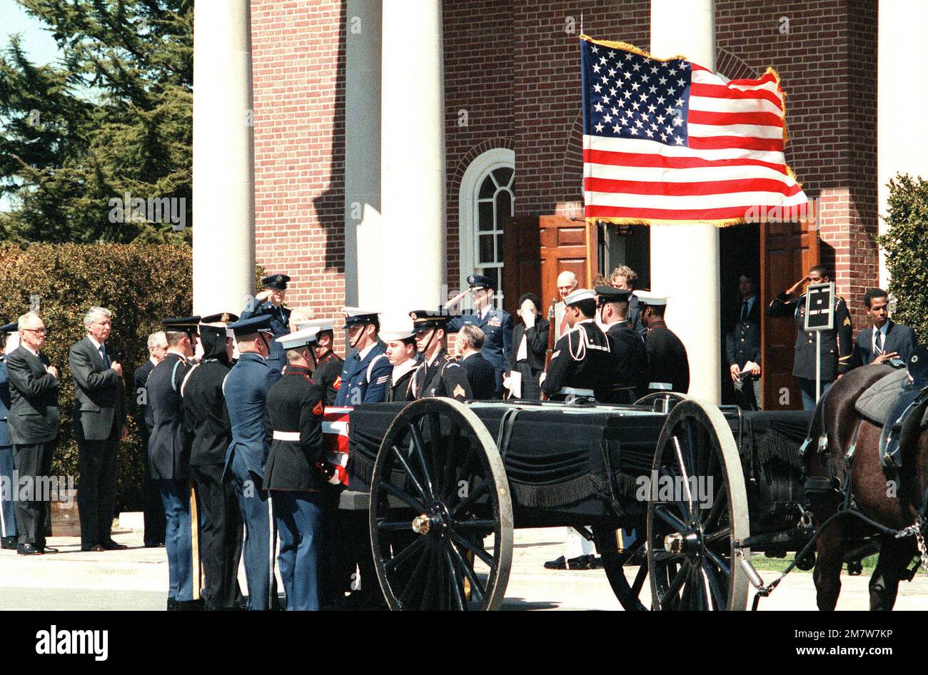 Members of a joint service honor guard place the casket on the caisson ...