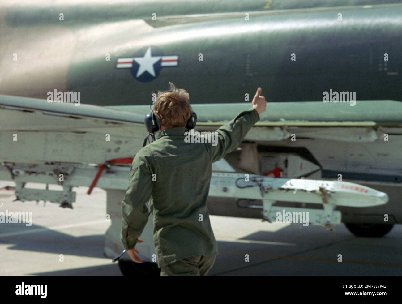 A ground crewman from the 37th Tactical Fighter Wing guides an F-4 ...