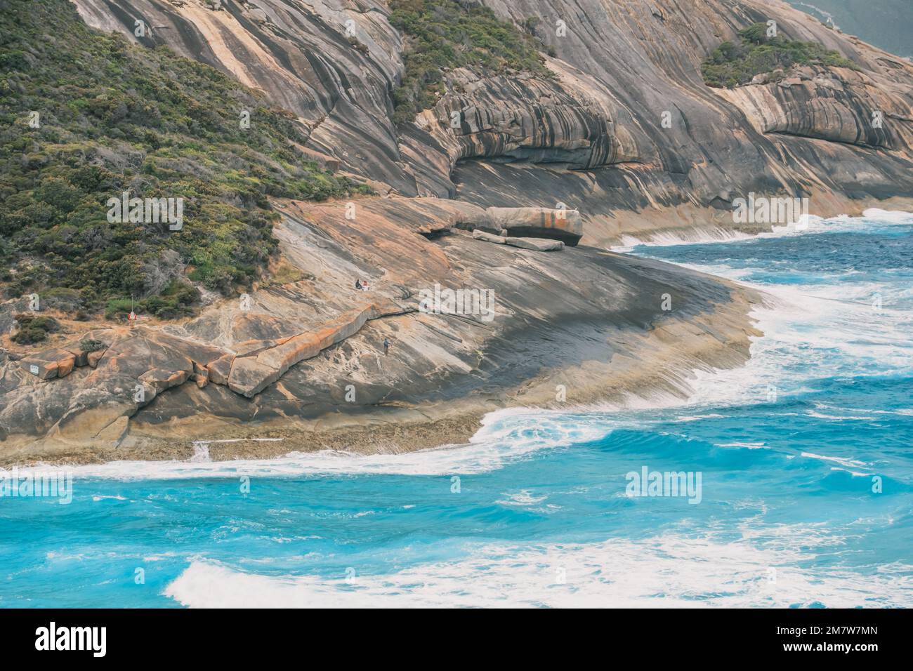 A man is fishing on big rocks, with big waves in Salmon hole, Albany ...