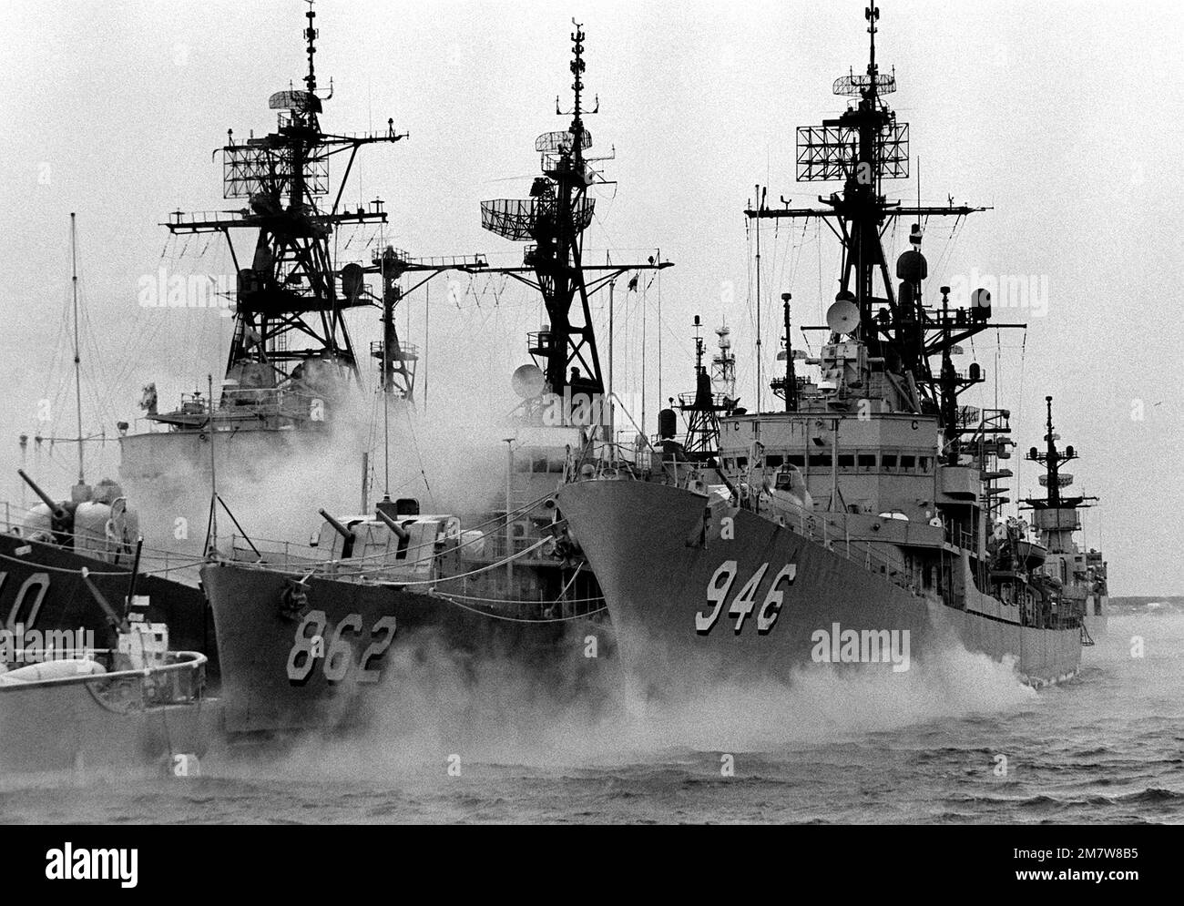 Mist surrounds three docked destroyers. The destroyers are, from left ...