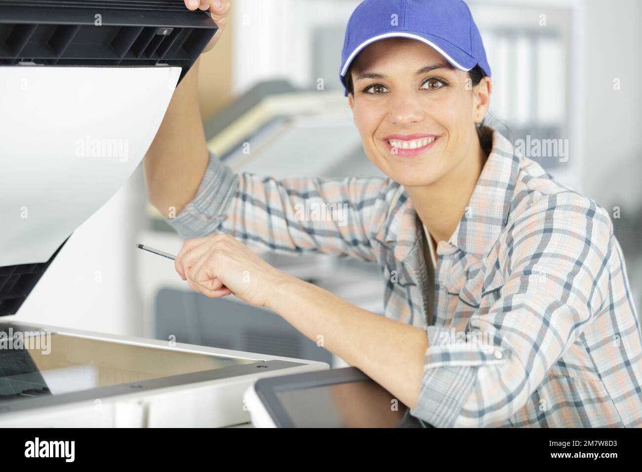 a happy technician programming photocopier Stock Photo - Alamy