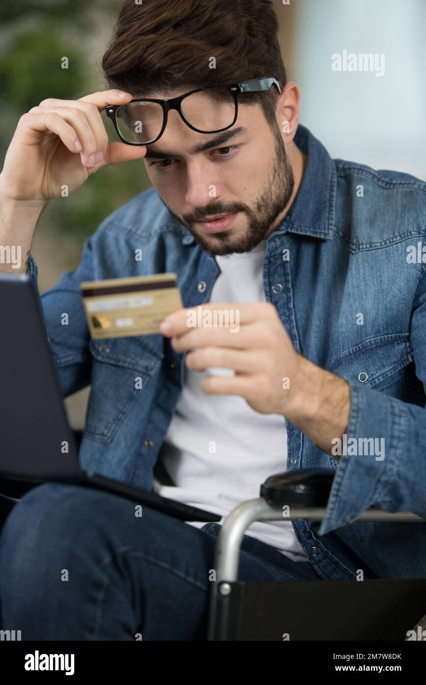 disabled person holds credit card and uses tablet Stock Photo - Alamy