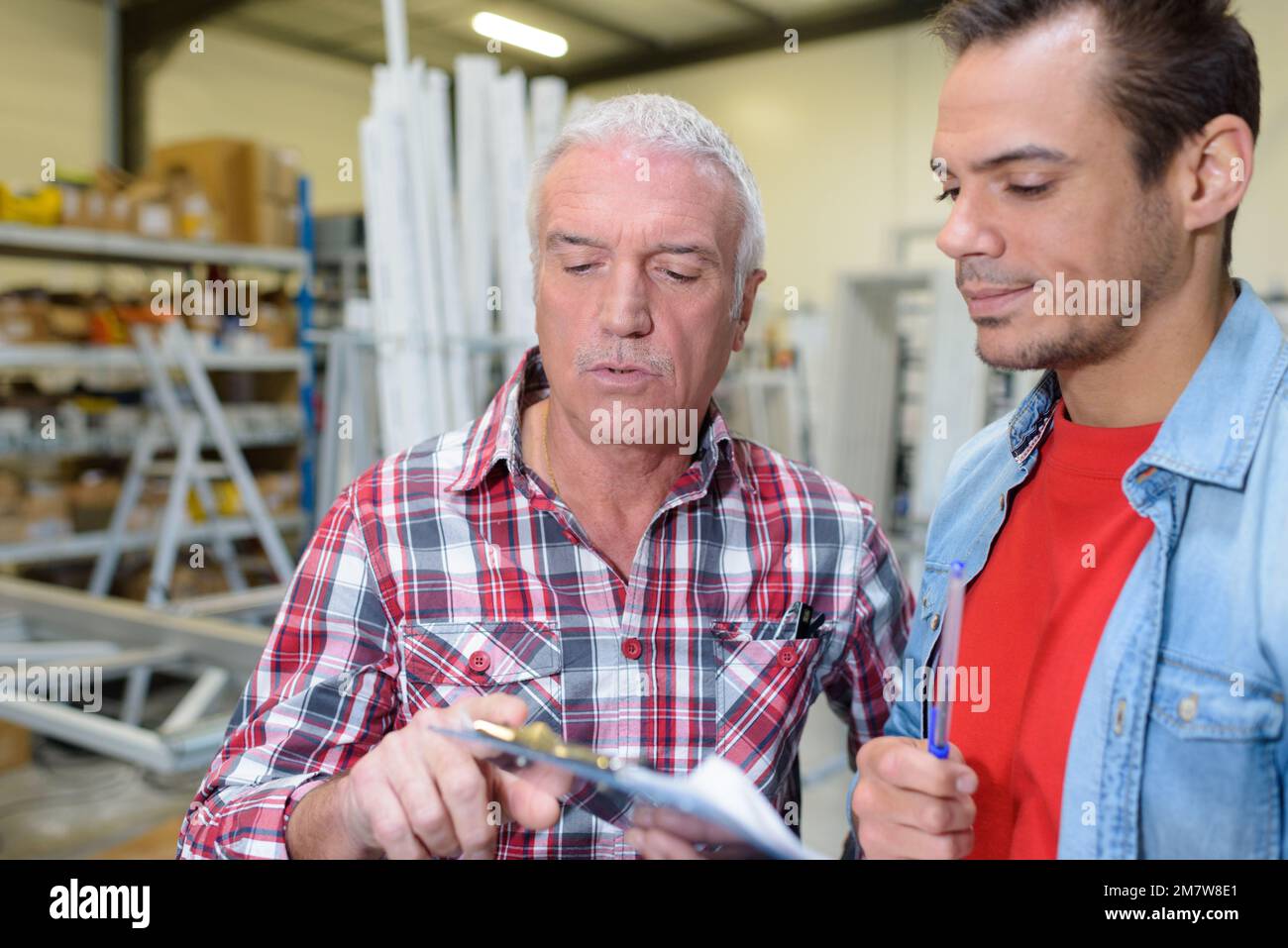 two warehouse workers filling in document Stock Photo - Alamy