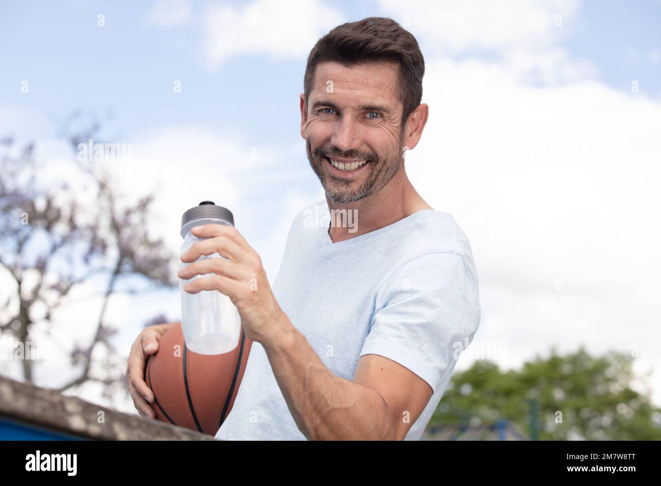 portrait of male basketball holding sports ball under arm Stock Photo ...