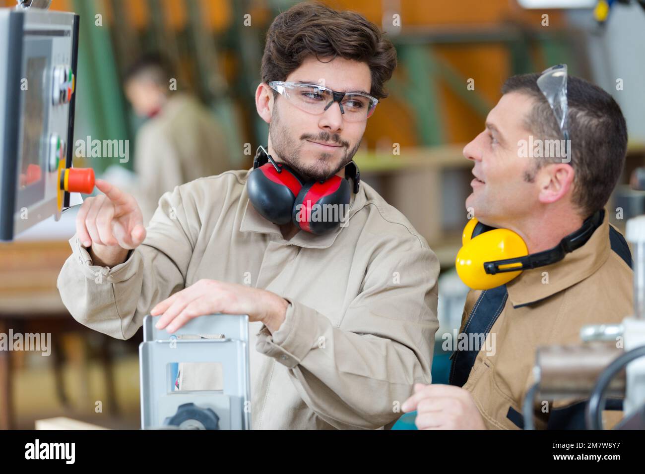 young machine operator pointing at a button Stock Photo - Alamy