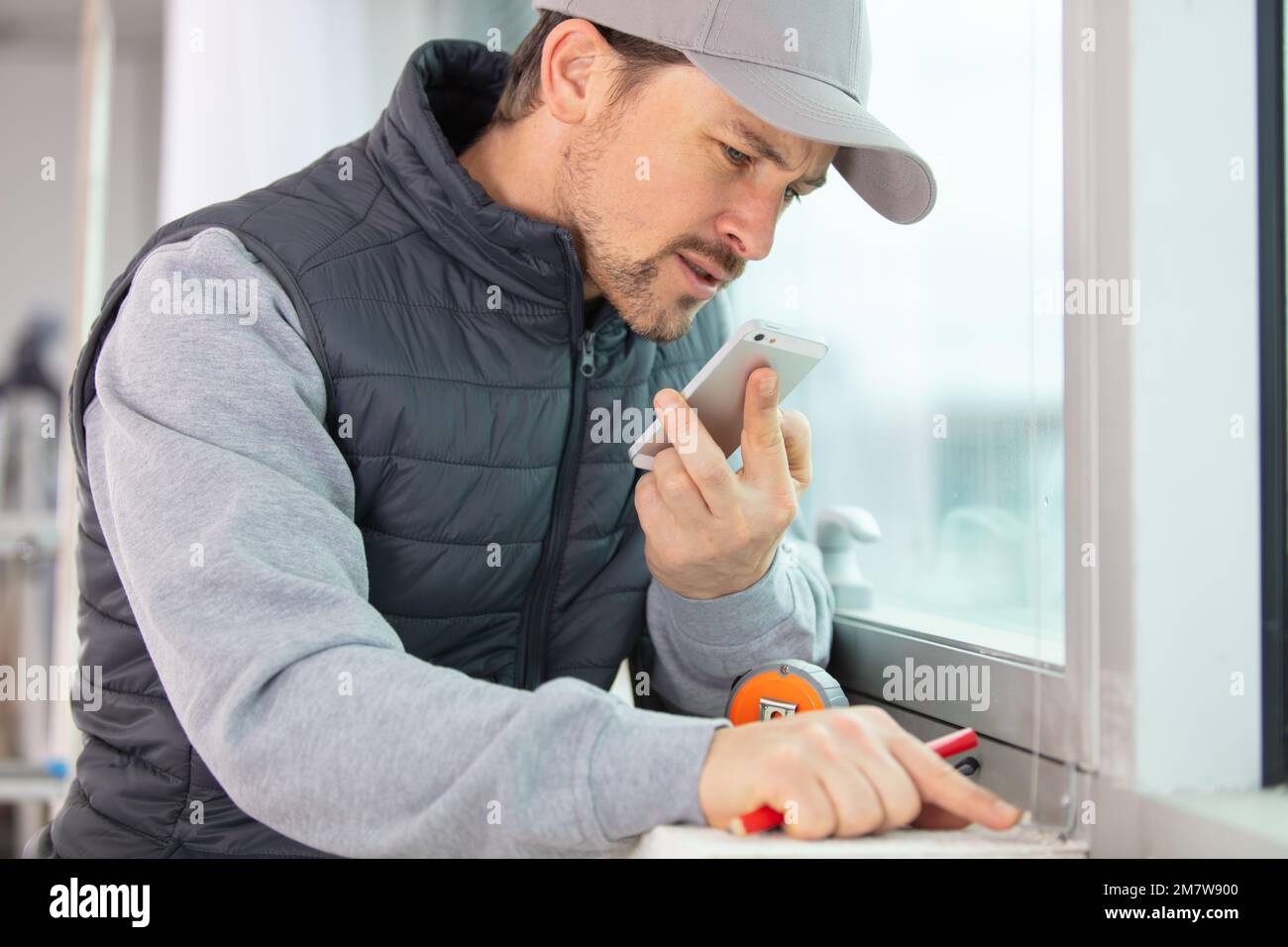 handsome young man installing bay window Stock Photo - Alamy