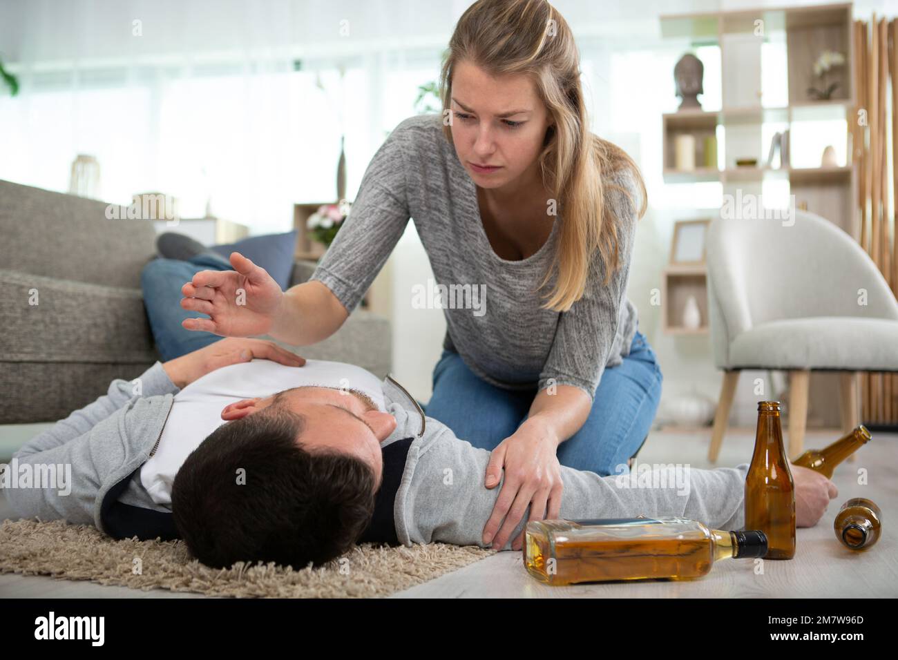 Drunk businessman holding whiskey lying on a counter Stock Photo - Alamy