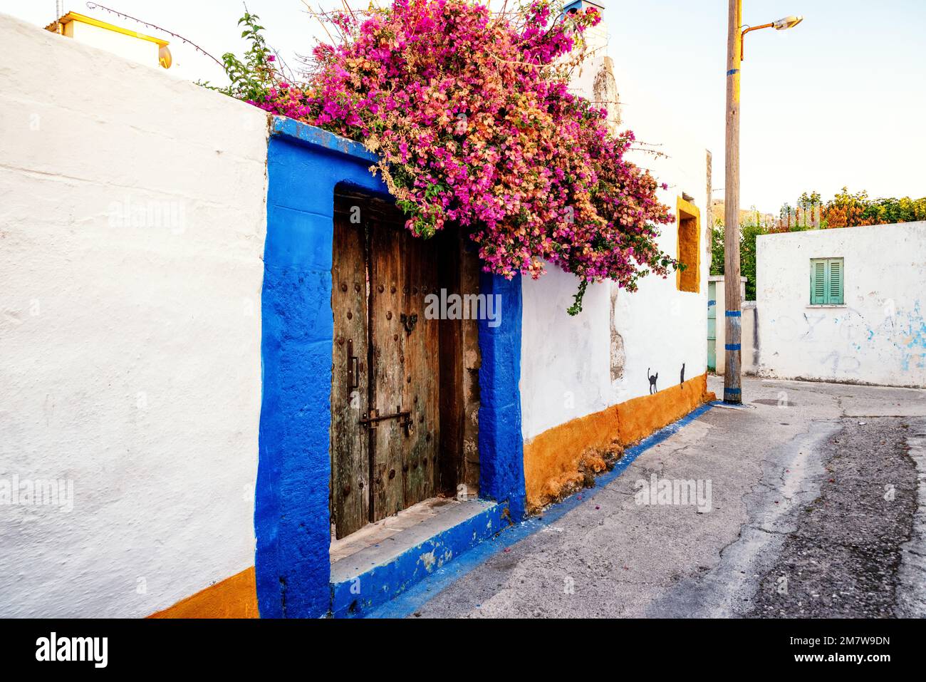 Traditional greek house with blooming violet flower in village ...