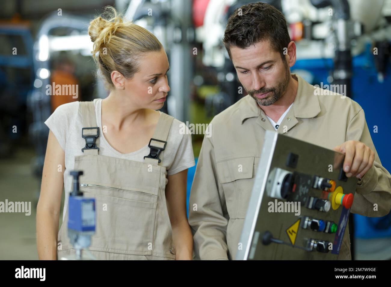 female and male operating machine in factory Stock Photo - Alamy