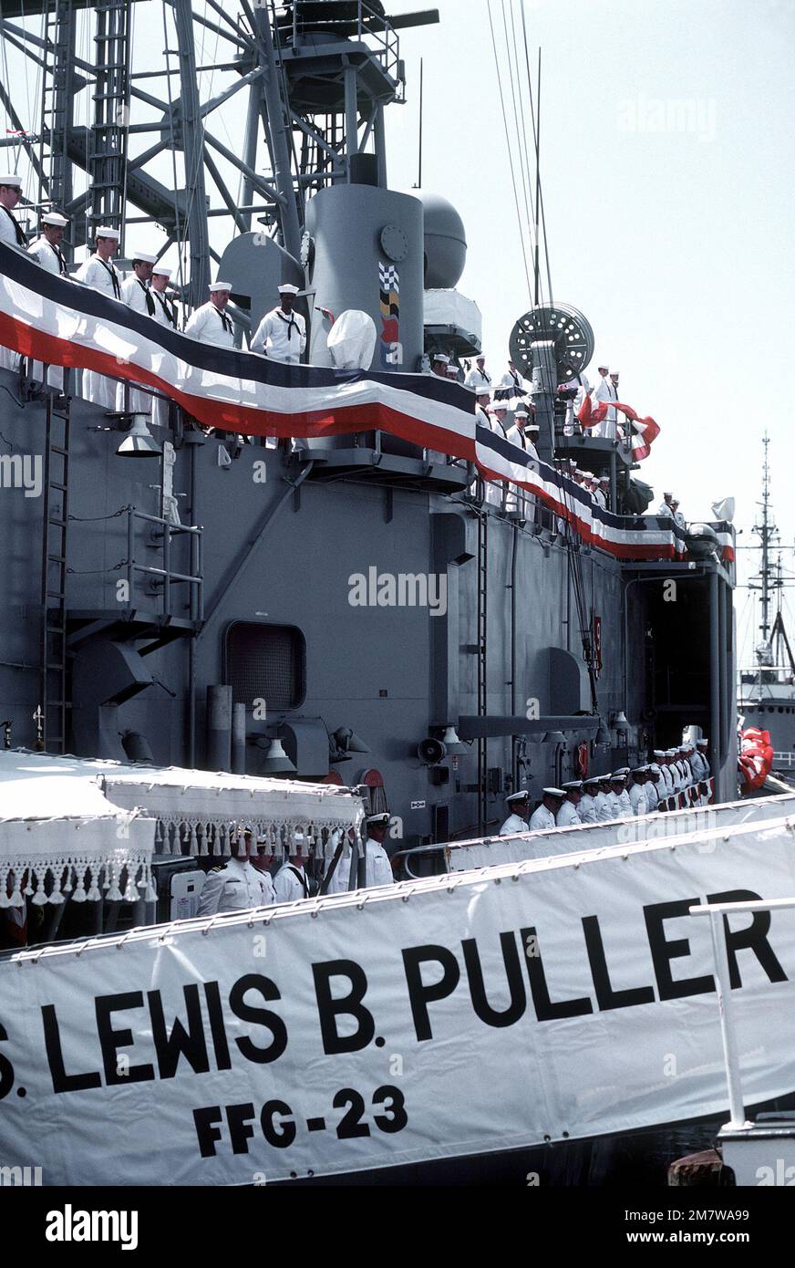 The crew of the guided missile frigate USS LEWIS B. PULLER (FFG-23) mans the rails during ...