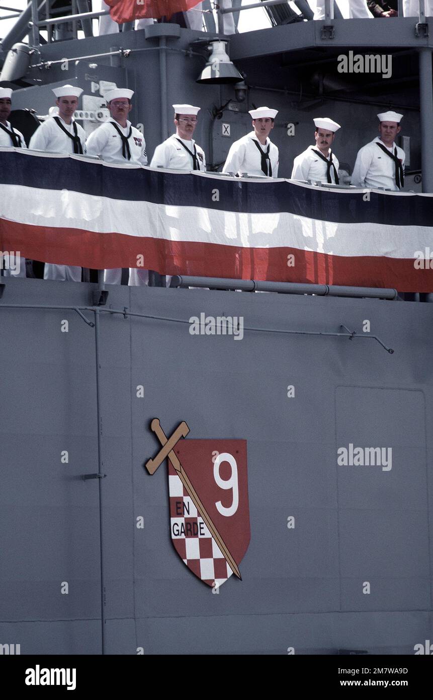 Crewmen line the rails of the guided missile frigate USS LEWIS B ...