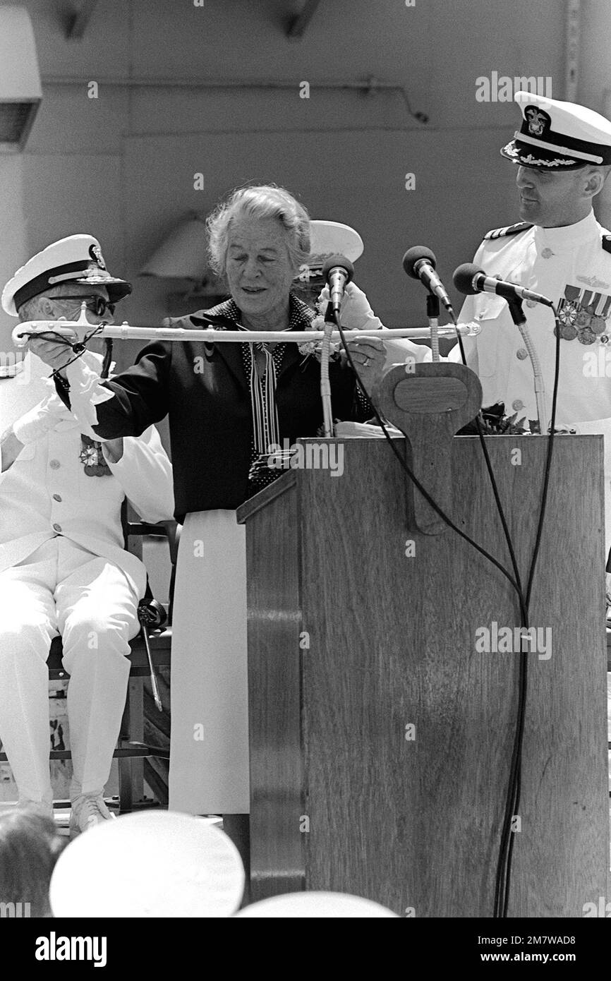 Mrs. Lewis B. Puller, ship's sponsor, presents a sword to the guided ...
