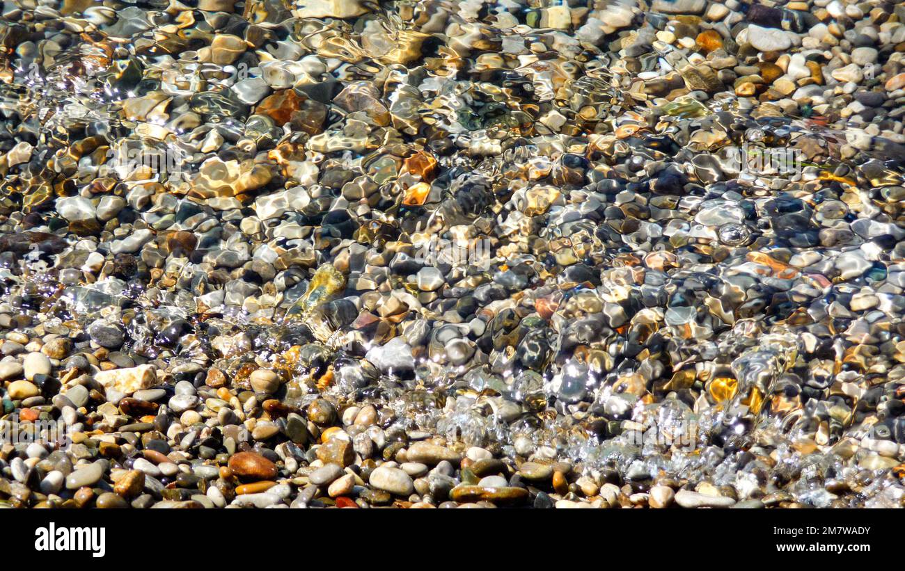 Crystal clear water of sea and pebby beach Stock Photo - Alamy