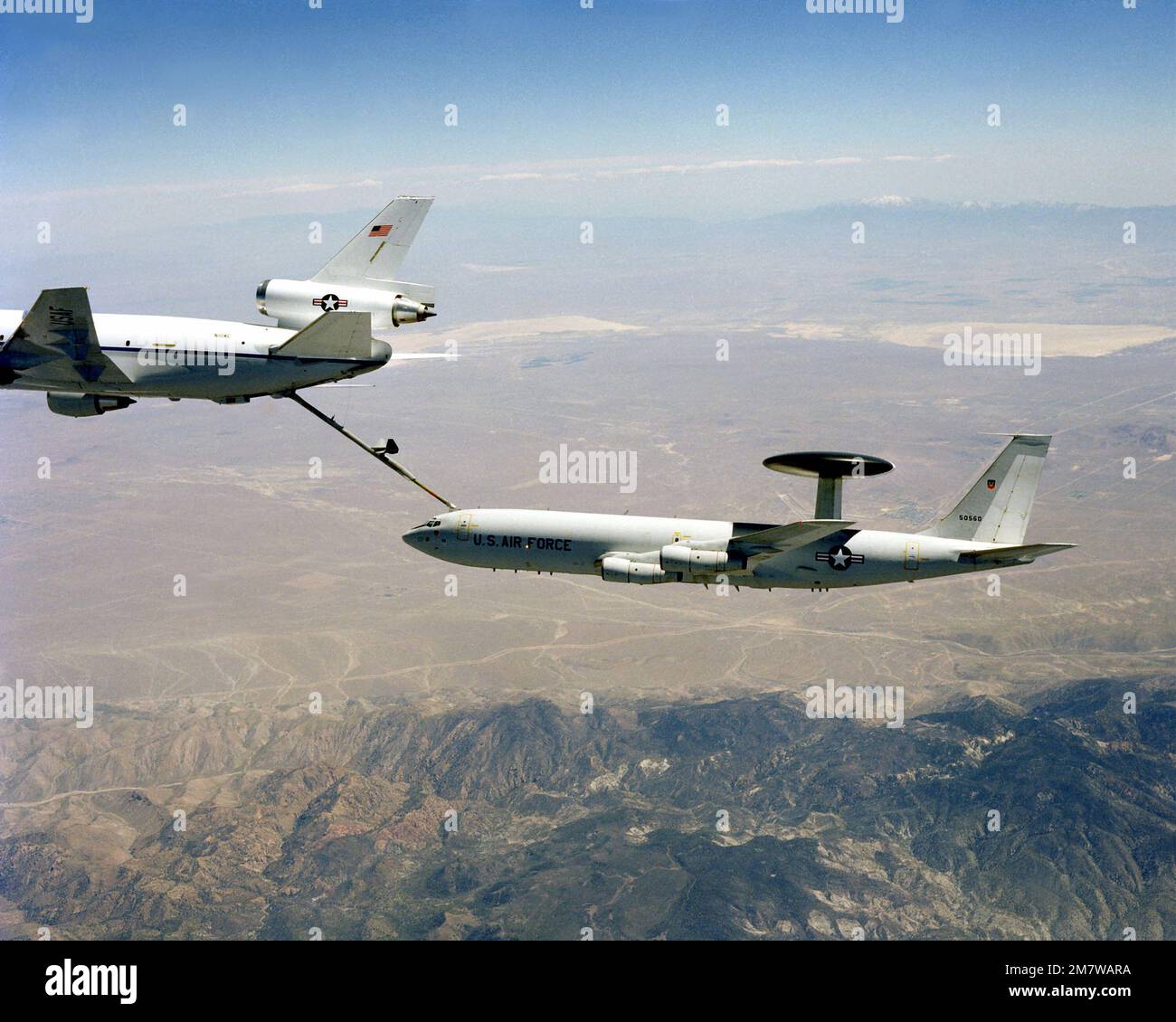 An air-to-air left side view of a KC-10A Extender aircraft refueling an ...