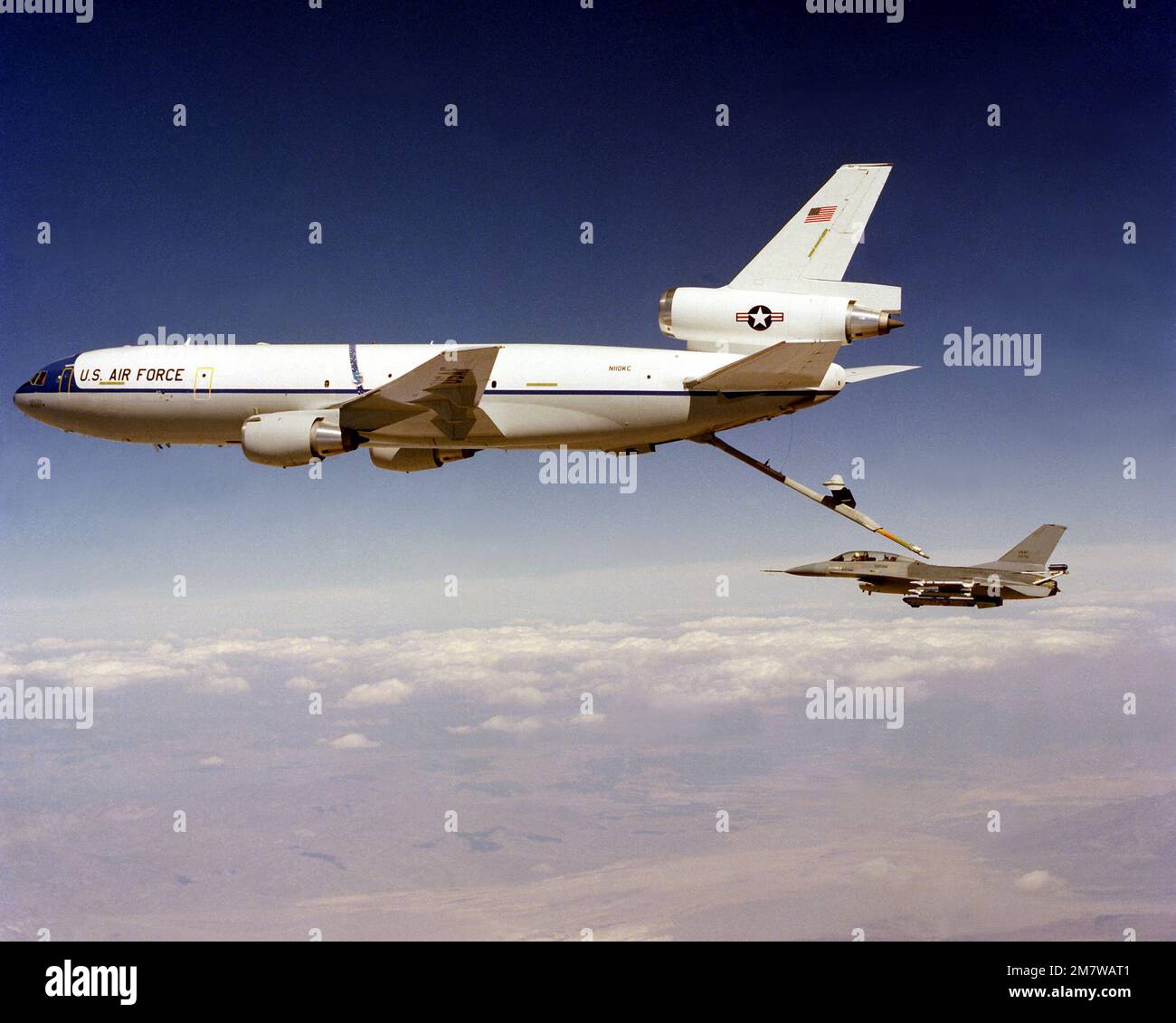 A left side view of a KC-10A Extender aircraft refueling an F-16 ...