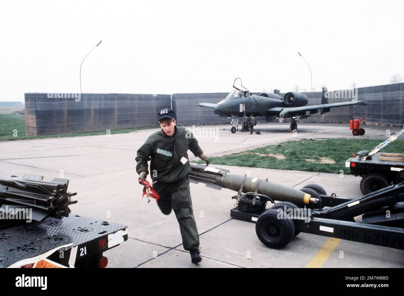 A ground crewman runs for cover during a simulated air raid, delaying ...